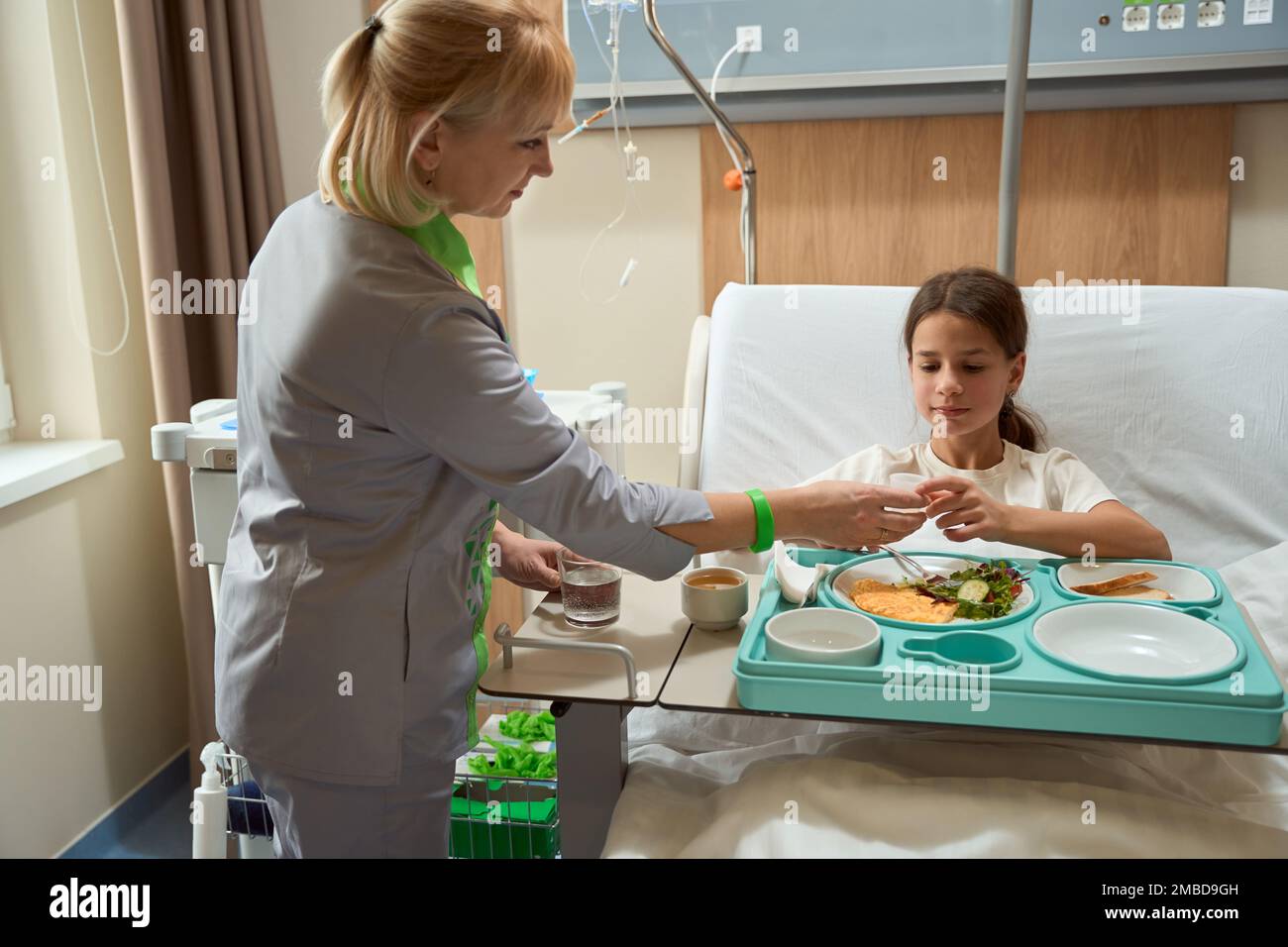 Medical worker giving medicine to patient while eating Stock Photo - Alamy