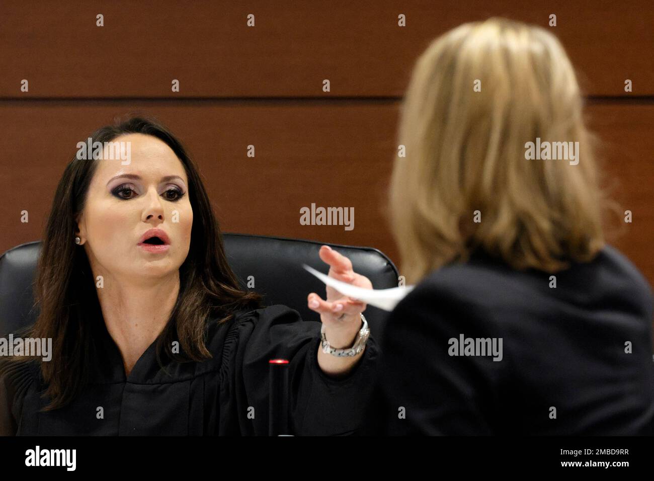 Judge Elizabeth Scherer receives a document from assistant Public ...