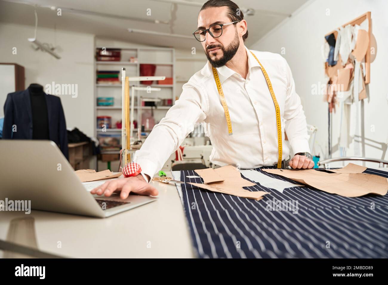 Focused clothier working on portable computer in atelier Stock Photo ...
