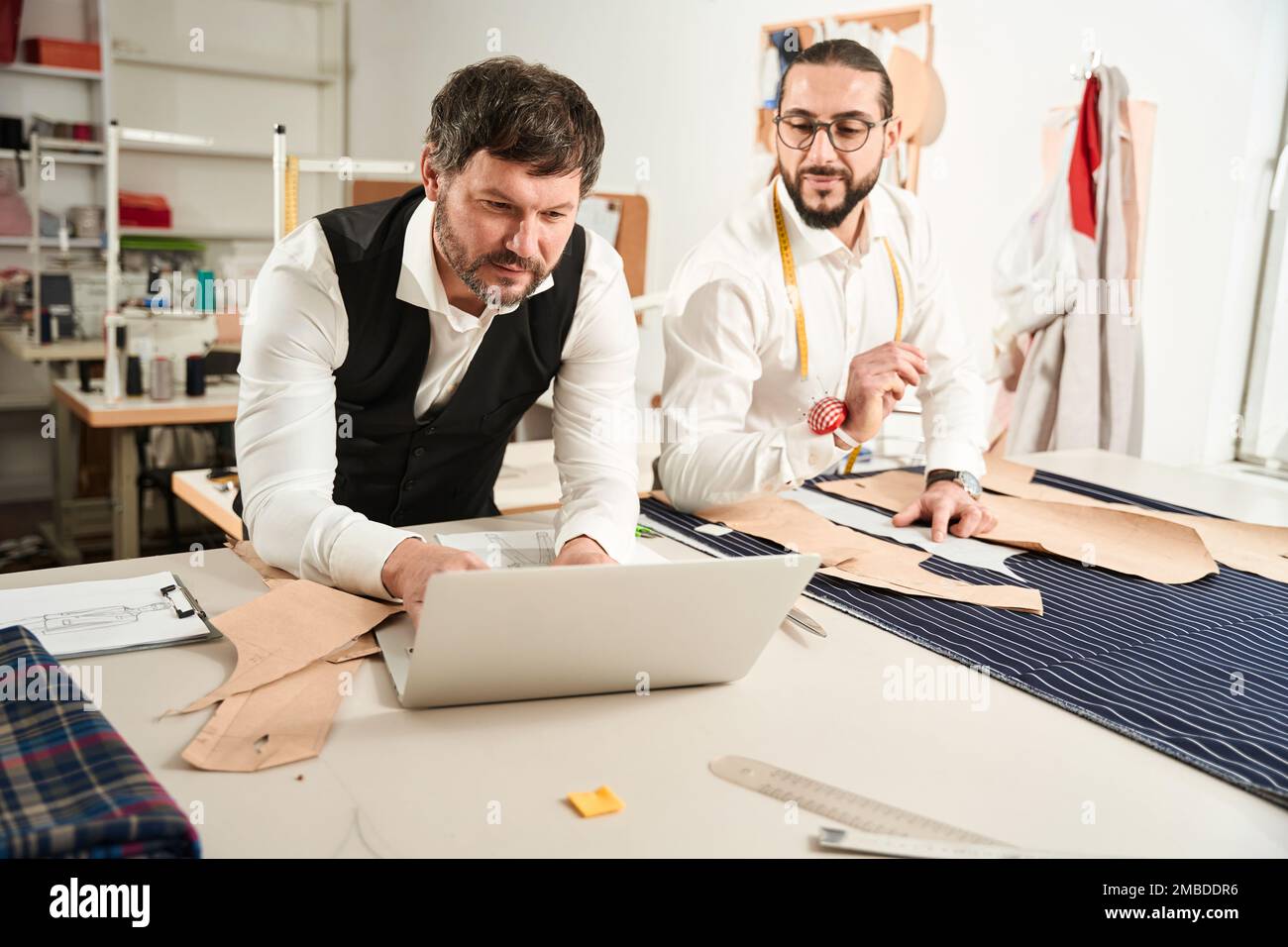 Two couturiers working together in modern atelier Stock Photo - Alamy