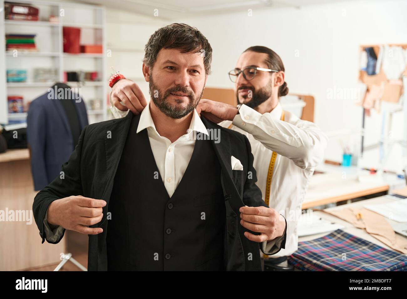 Male client trying on new suit during fitting session Stock Photo - Alamy