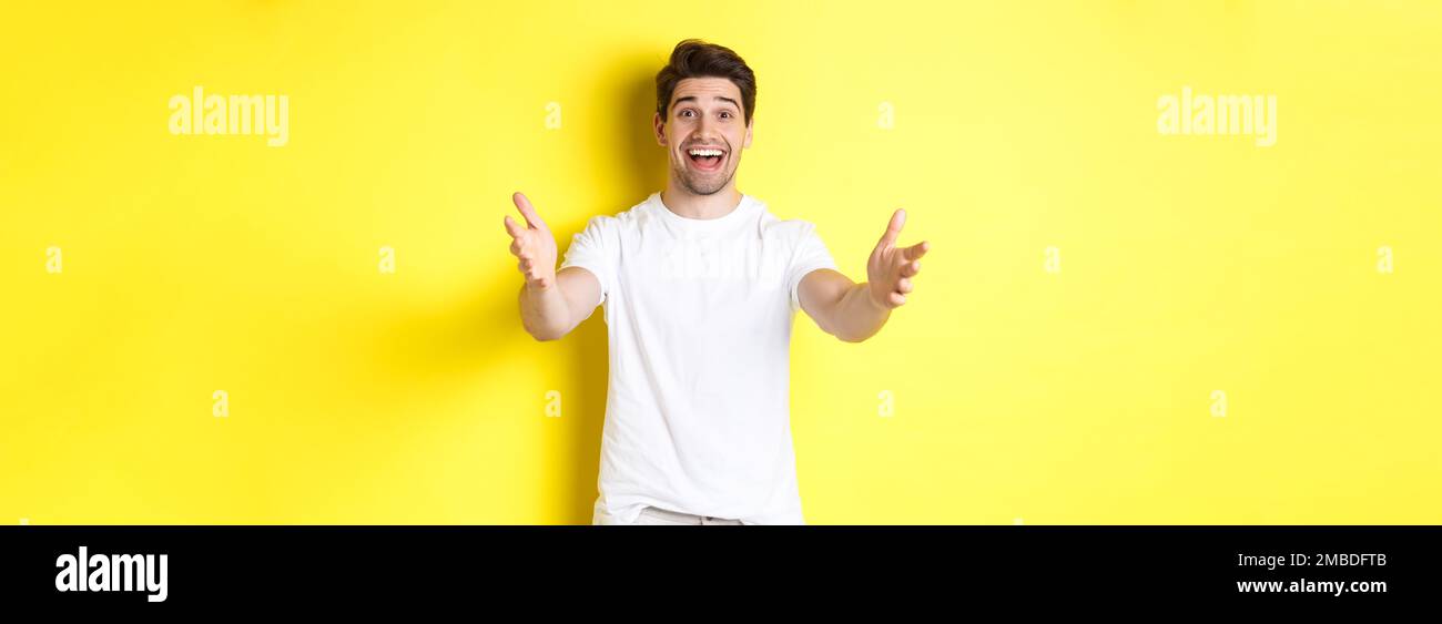 Excited handsome guy stretching hands forward, reaching for hug ...