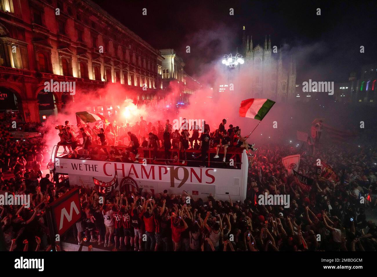 Thousands of fans cheer as a bus carries the triumphant AC Milan soccer ...