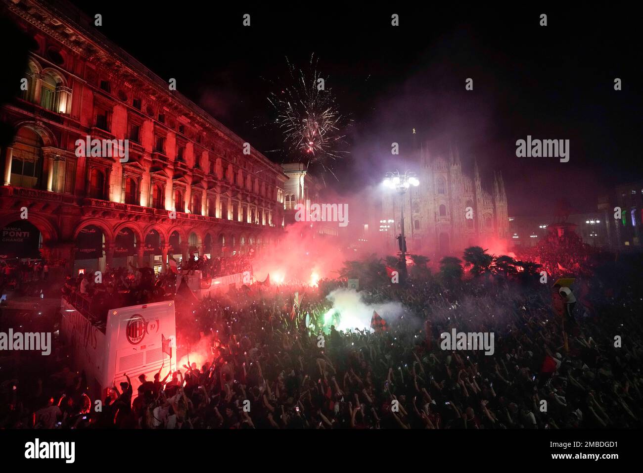 Thousands of fans cheer as a bus carries the triumphant AC Milan soccer ...