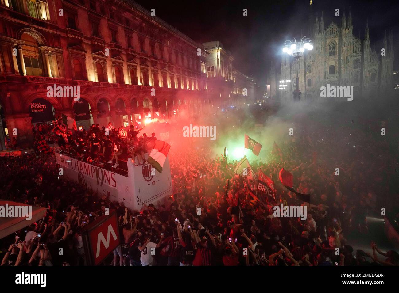 Thousands of fans cheer as a bus carries the triumphant AC Milan soccer ...