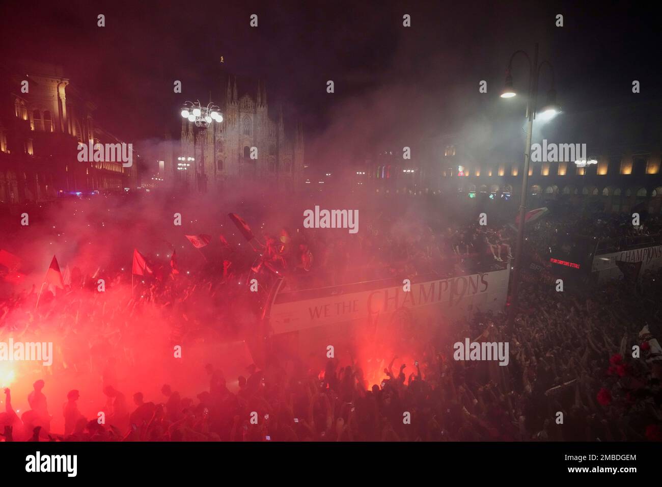 Thousands of fans cheer as a bus carries the triumphant AC Milan soccer ...