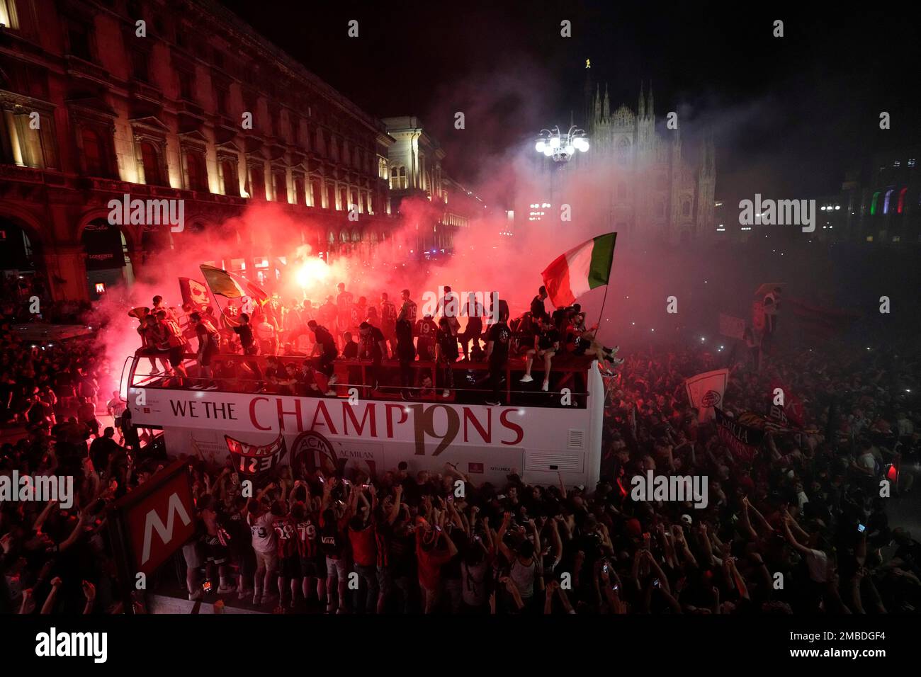 Thousands of fans cheer as a bus carries the triumphant AC Milan soccer ...