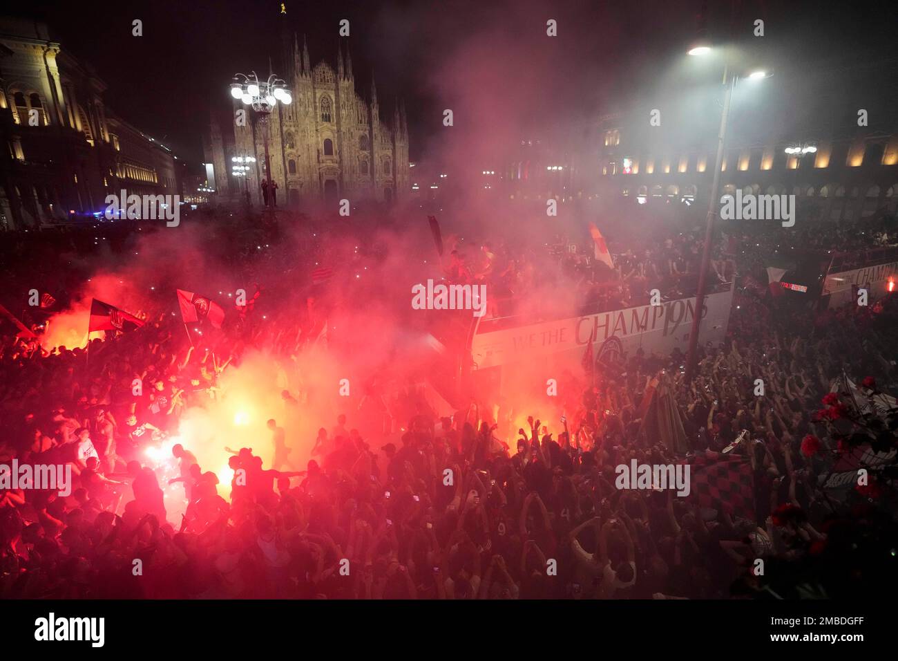 Thousands of fans cheer as a bus carries the triumphant AC Milan soccer ...