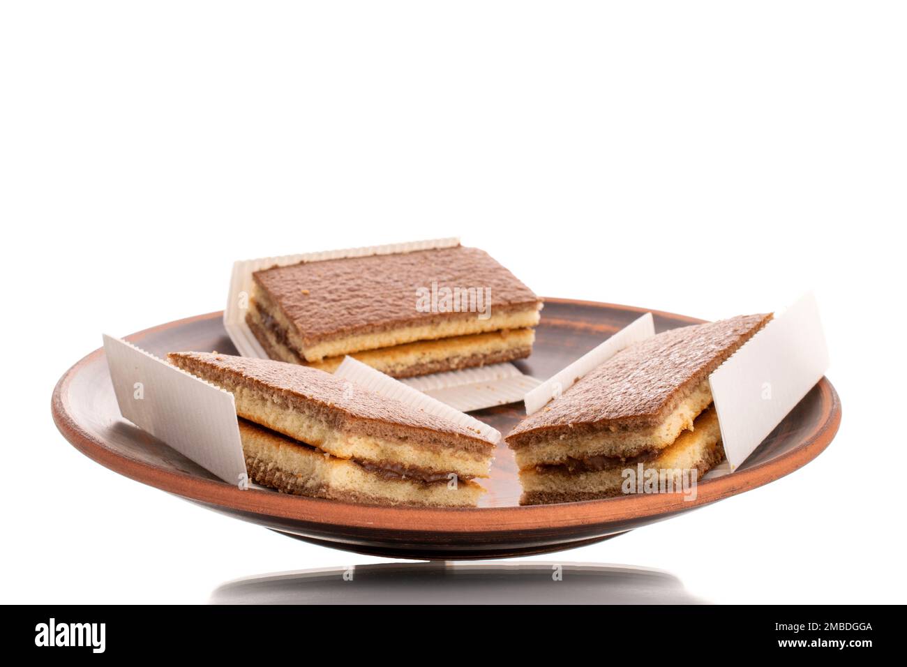 Three mini biscuits with cocoa on a clay plate, macro, isolated on a ...