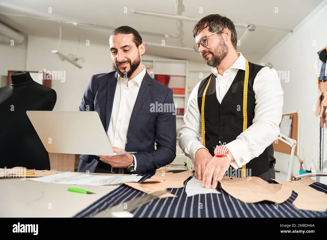 Joyous couturiers working on new menswear collection Stock Photo - Alamy