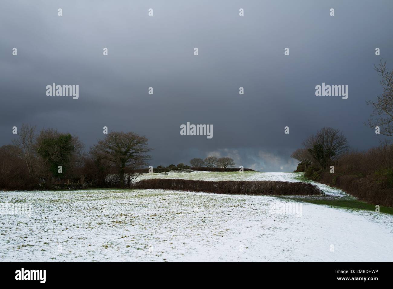 An approaching snow storm in fields near the village of Tregarth in ...