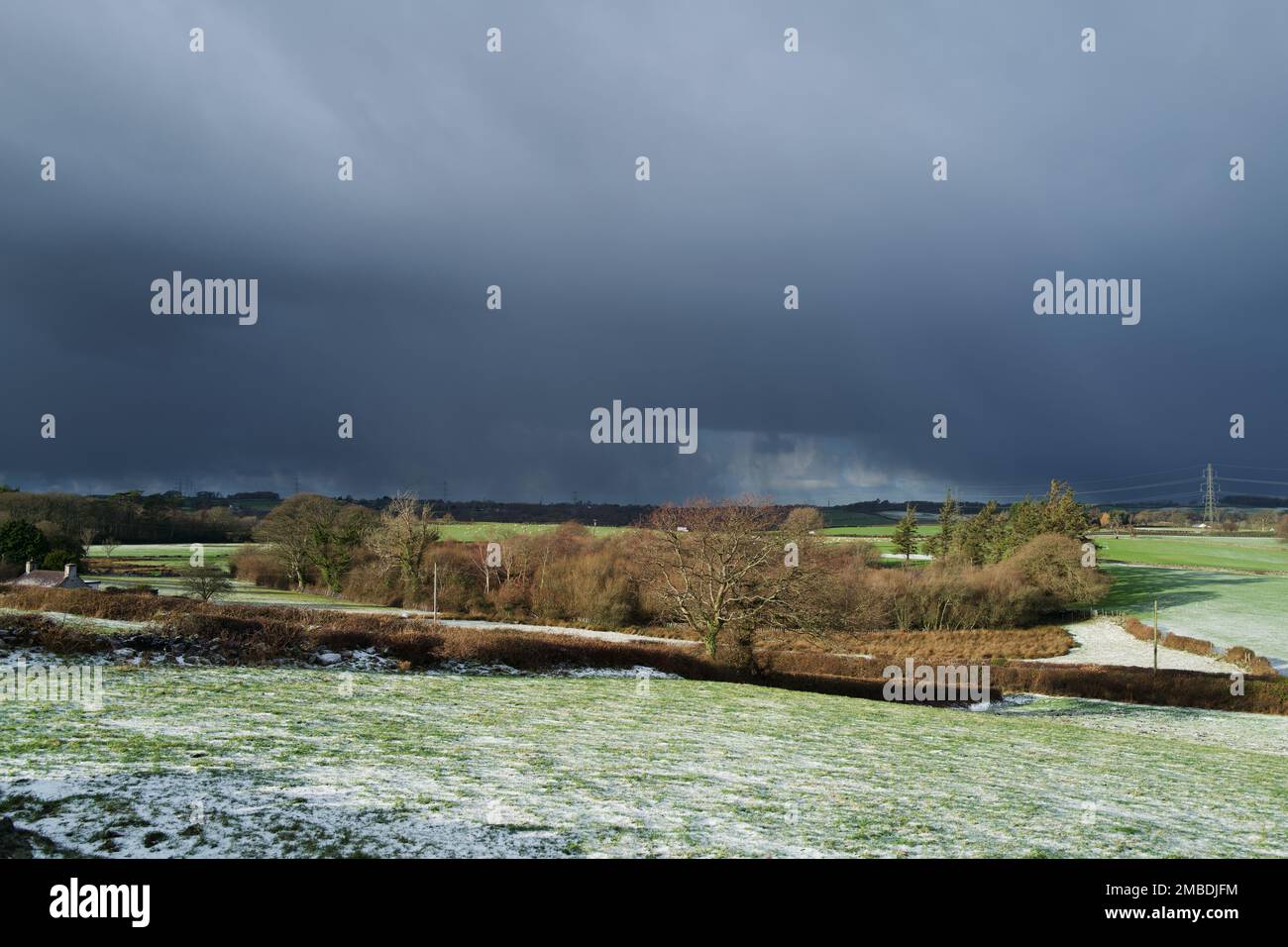 An approaching snow storm in fields near the village of Tregarth in ...