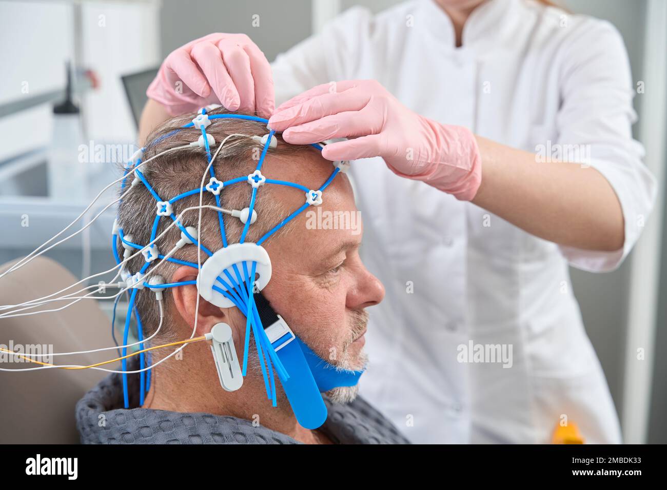 Diagnostician doctor attaches electrodes to the patient head Stock ...