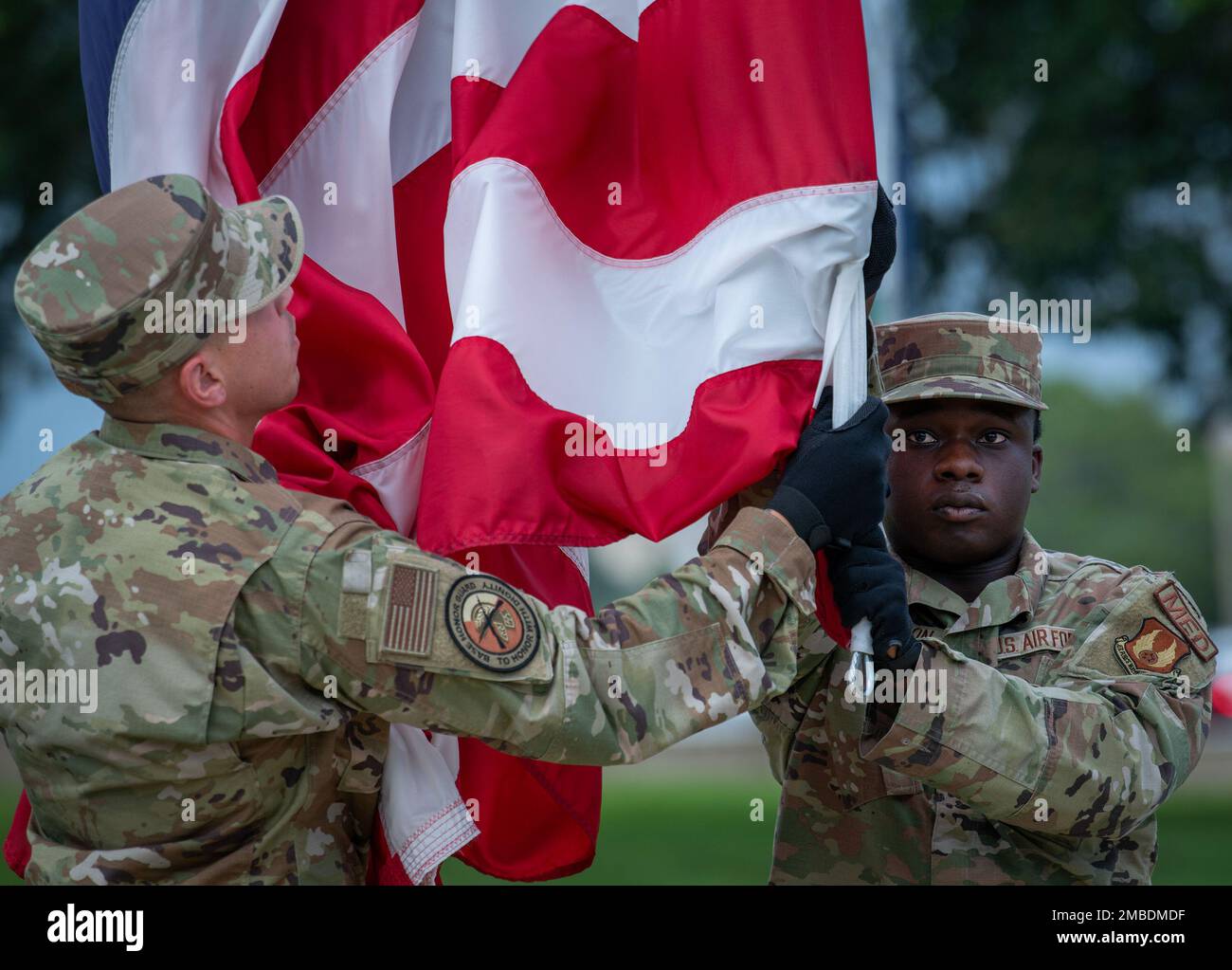 Airmen from the 96th Test Wing lower and gather the base flag during a ...