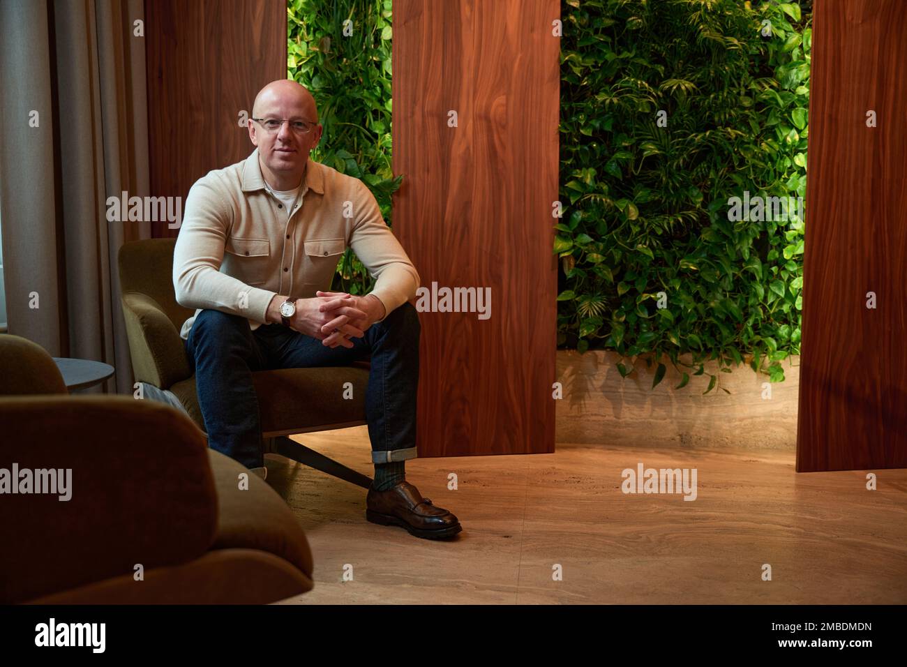 Energetic man sits in a room with a stylish design Stock Photo - Alamy