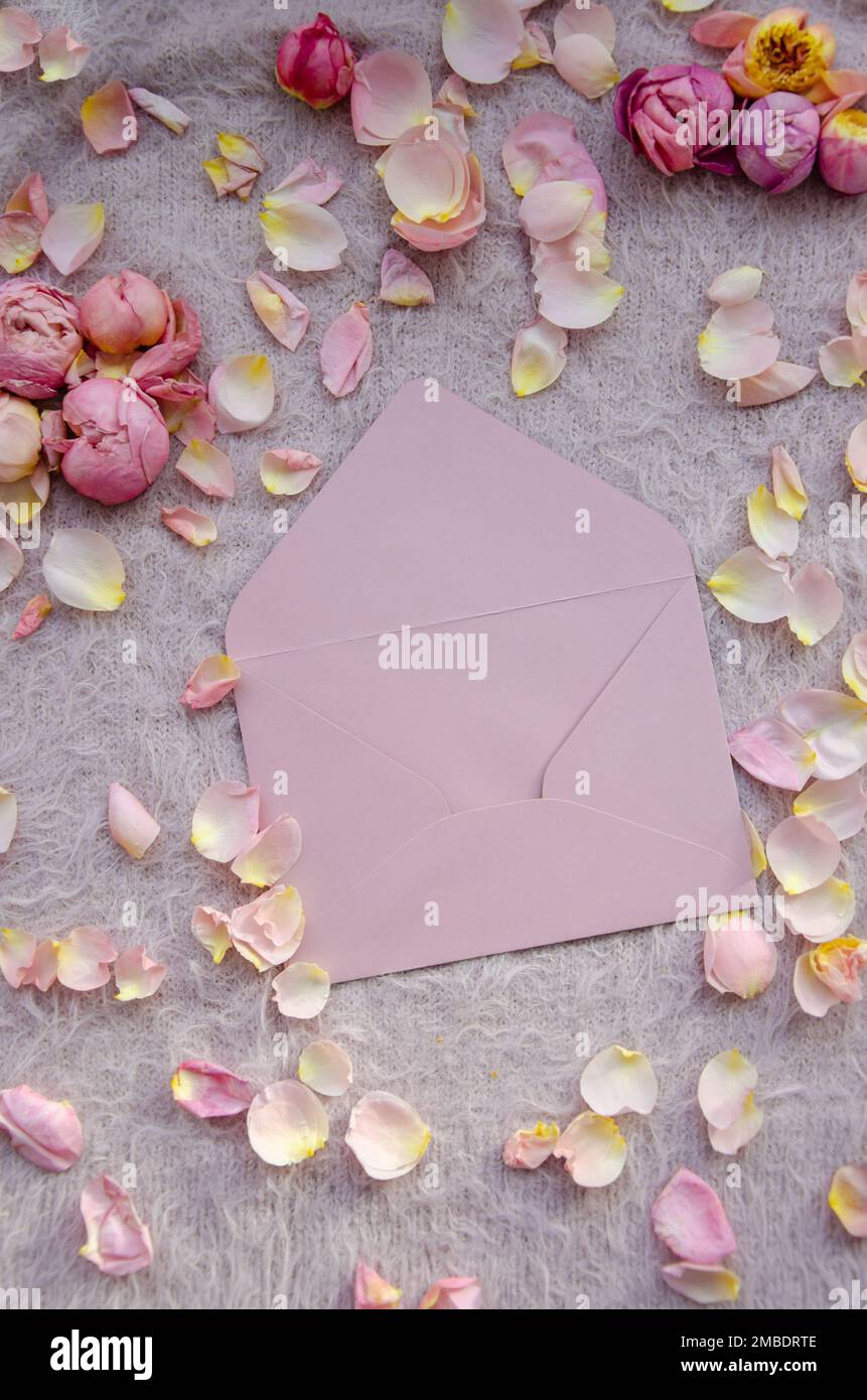 Craft pink envelope with small petals and rose buds on pink knitted ...