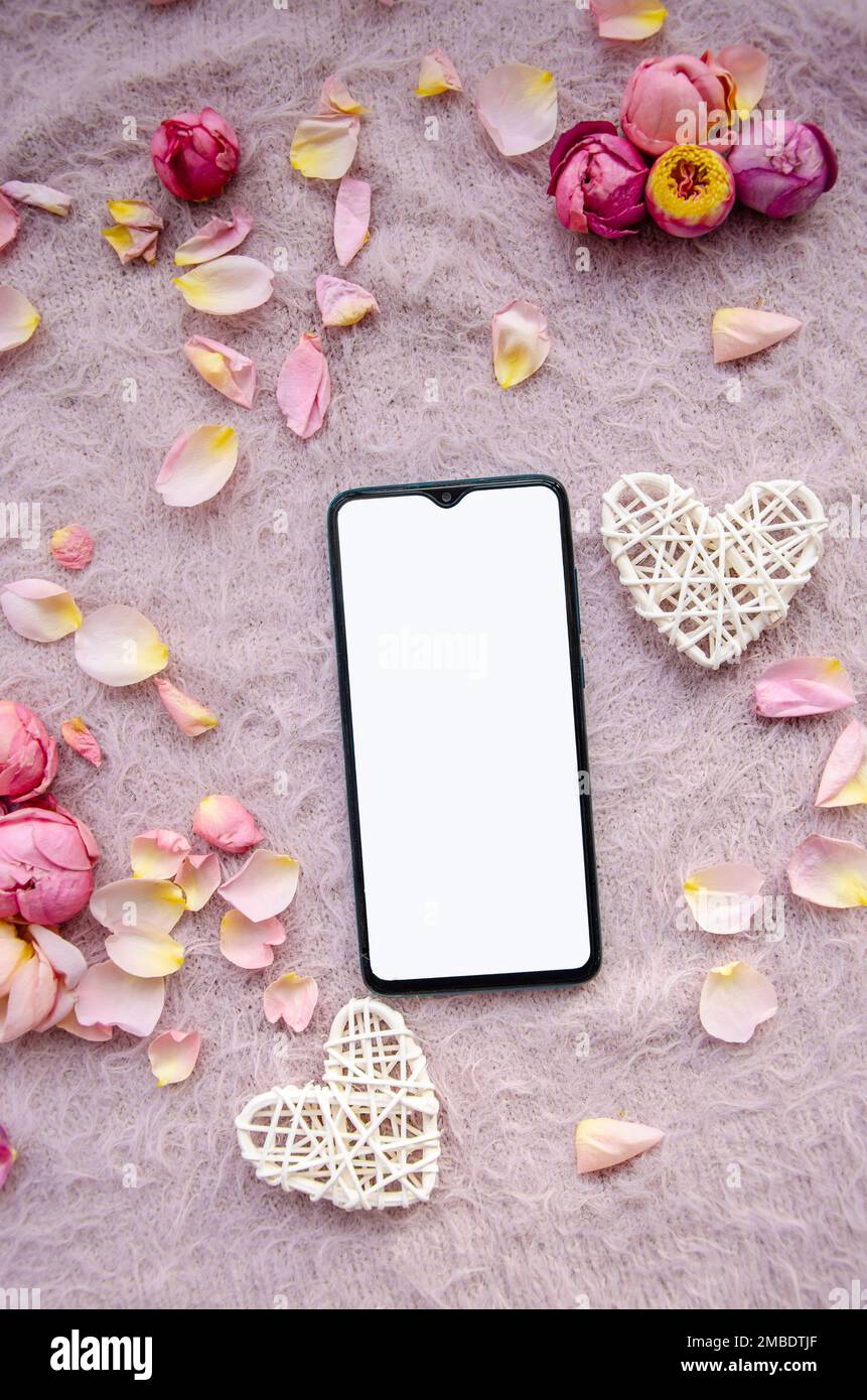 Digital smartphone, blank screen with small petals and white tangled ...