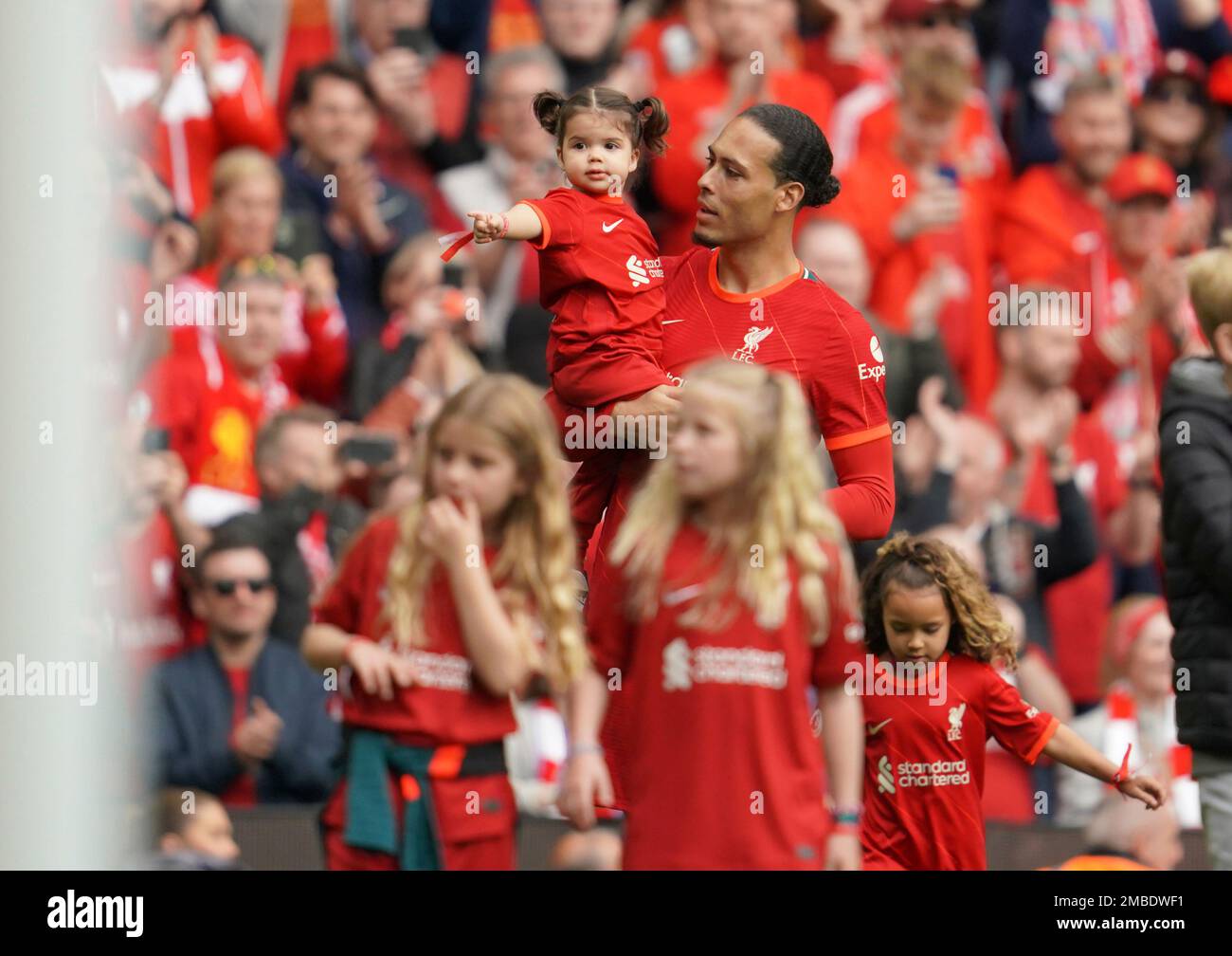 Liverpool's Virgil van Dijk walks on the pitch with his child after the ...