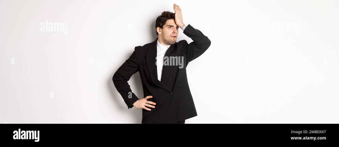 Portrait of shocked and distressed businessman in black suit, slap ...