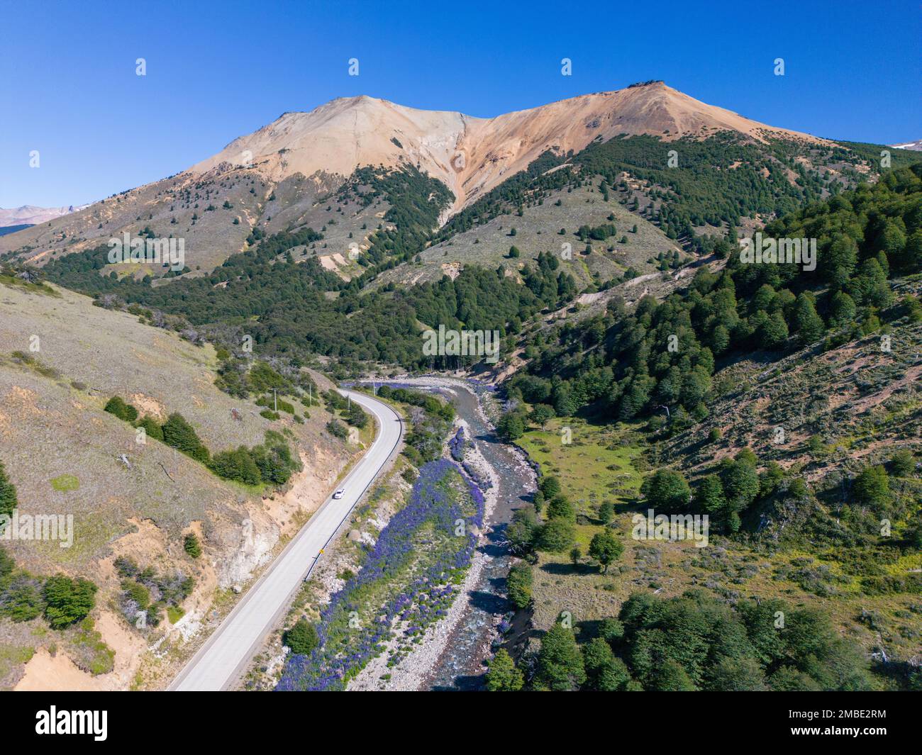 Aerial view of the Carretera Austral with a crystal clear creek along ...