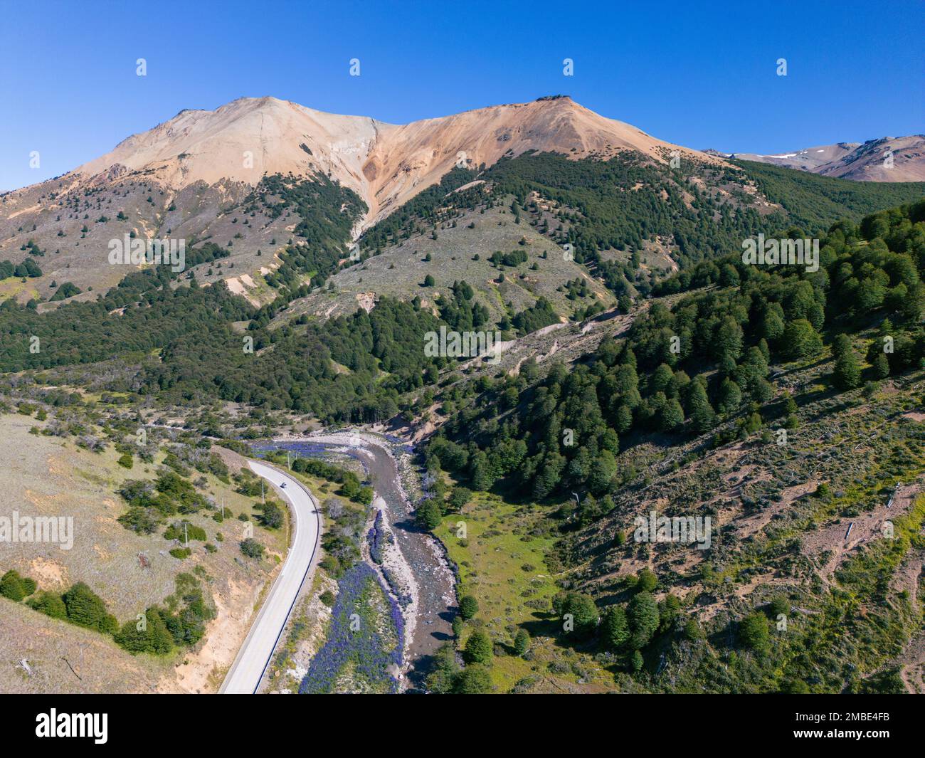 Aerial view of the Carretera Austral with a crystal clear creek along ...