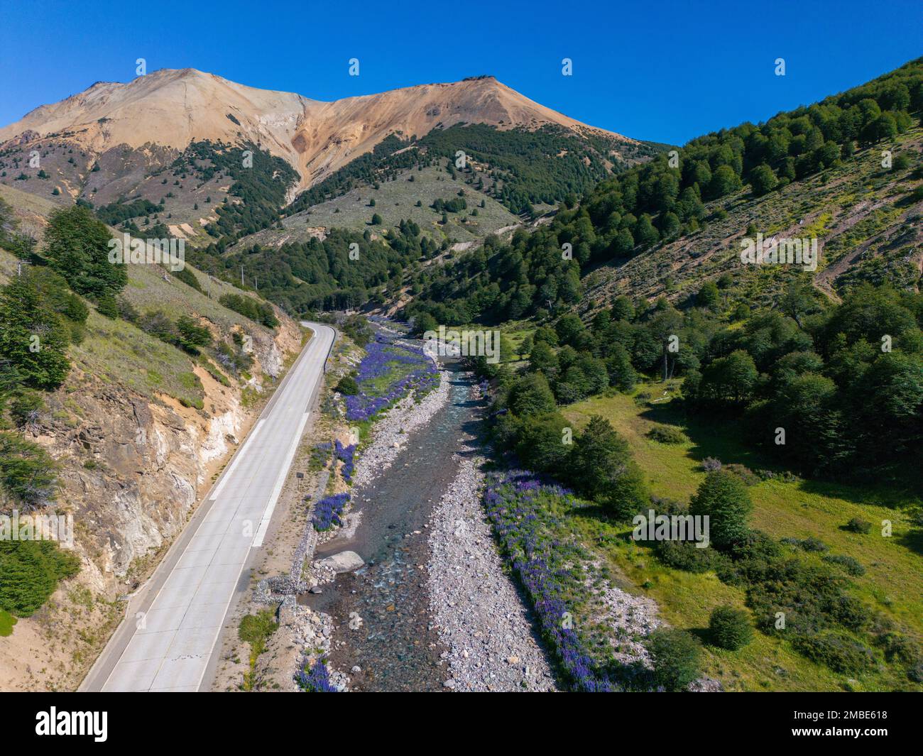 Aerial view of the Carretera Austral with a crystal clear creek along ...