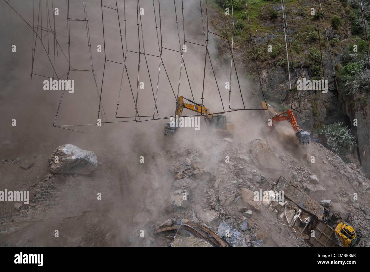 Earth movers dig through the rubble of a collapsed tunnel are engulfed ...