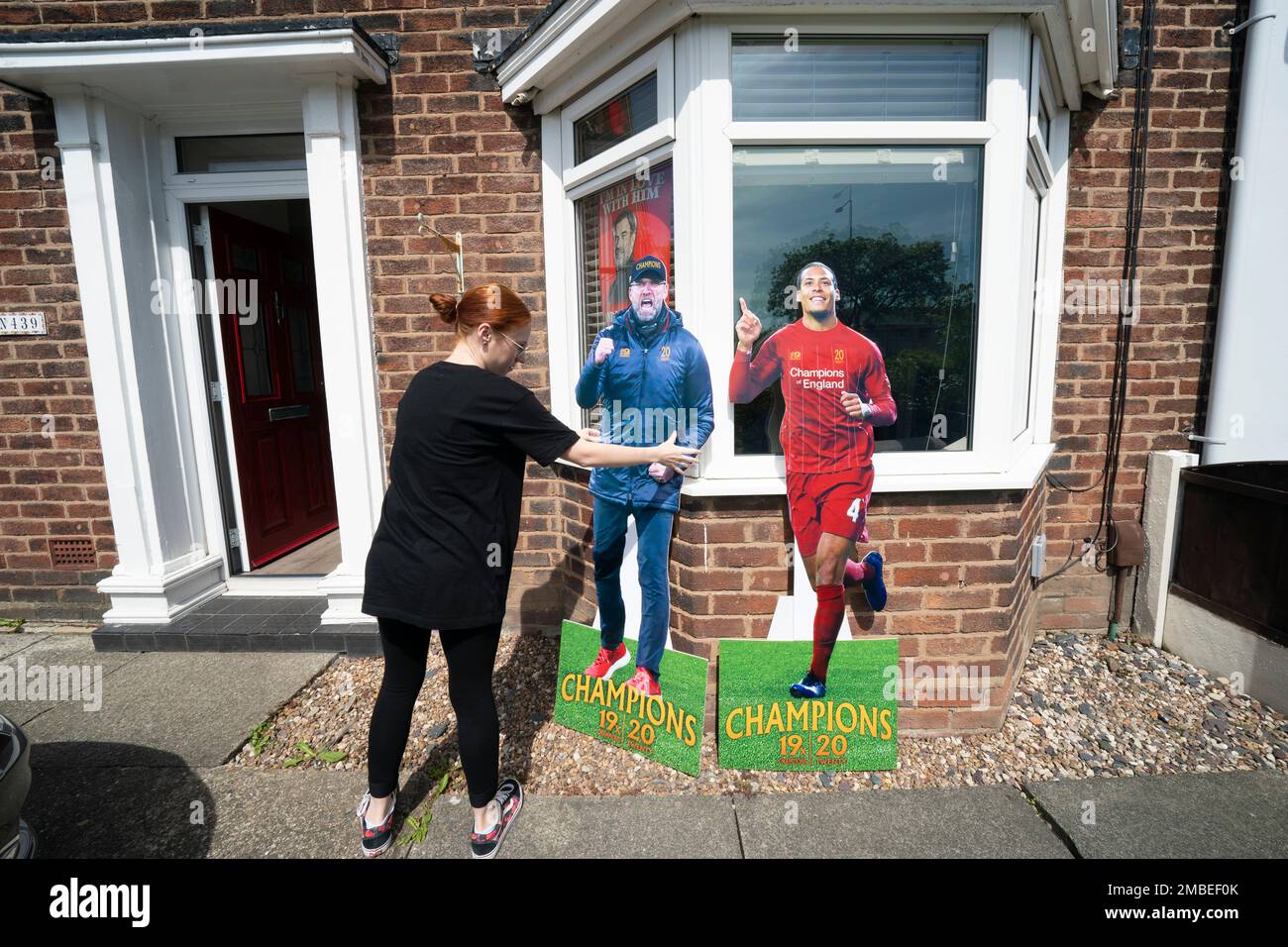 Liverpool supporter Hannah Naylor places a cutout of Liverpool manager ...
