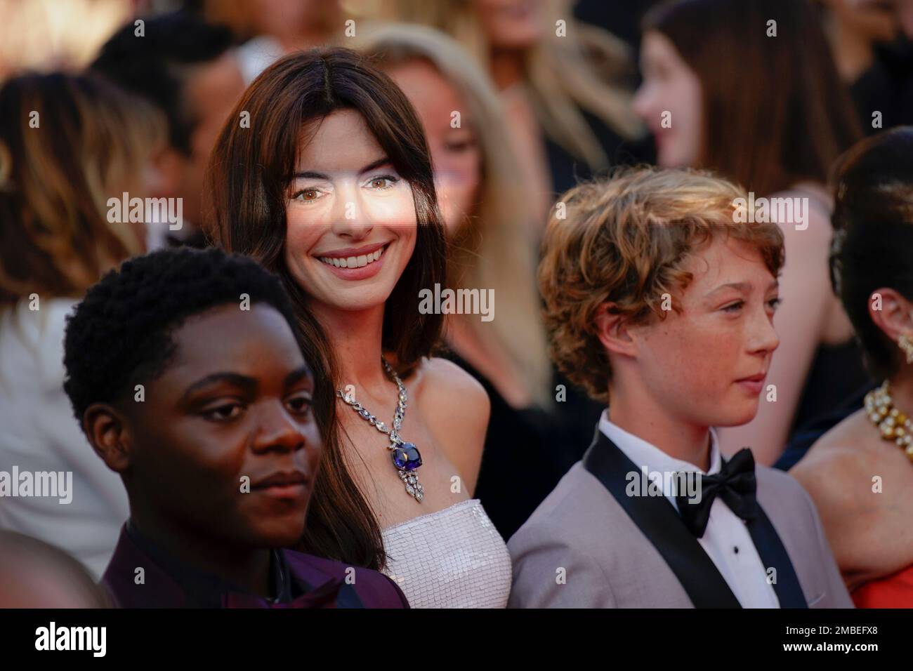 Anne Hathaway, centre, poses with Jaylin Webb, left, and Michael Banks ...