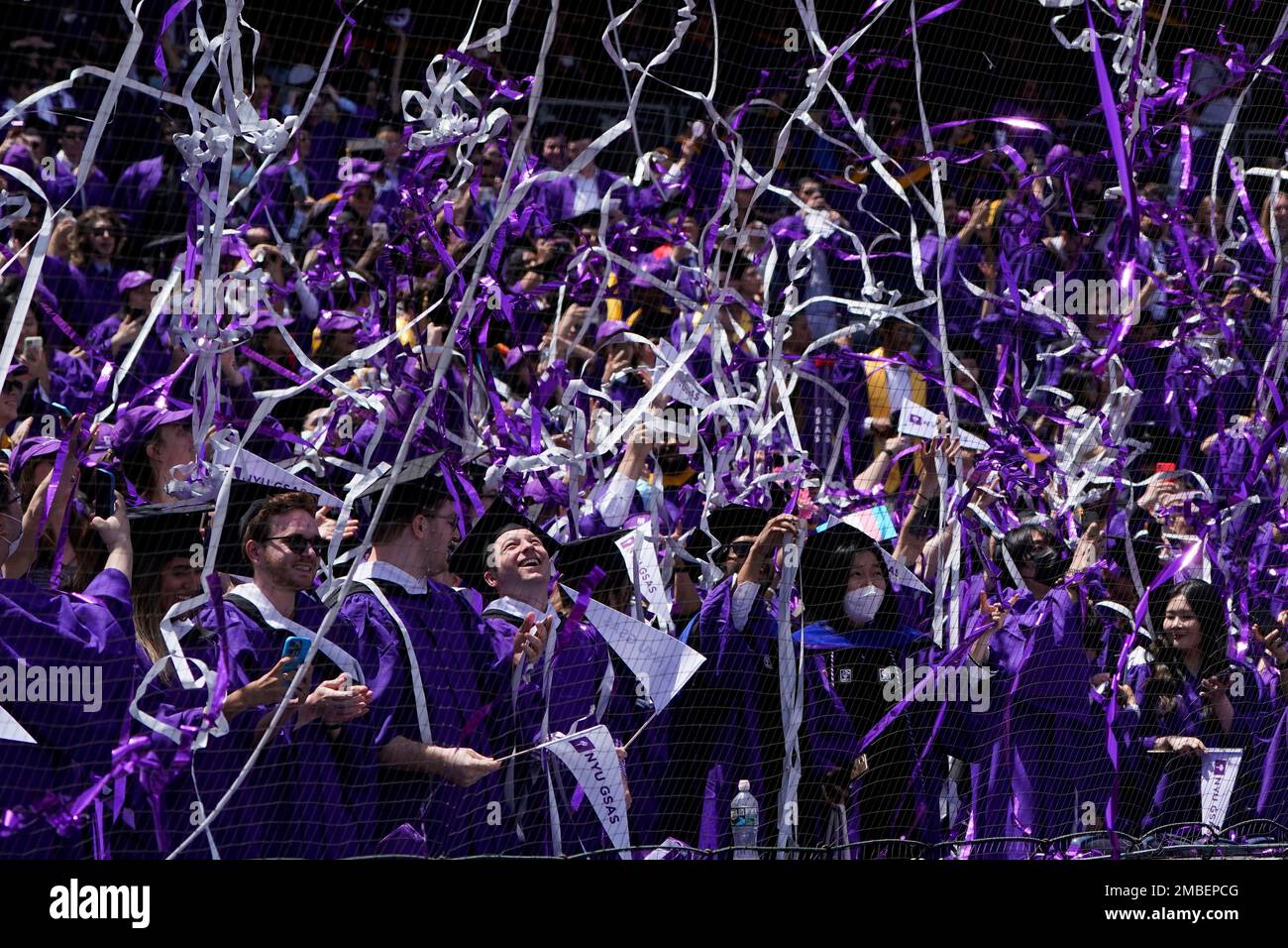 Confetti drops on graduates as they celebrate during a graduation ...