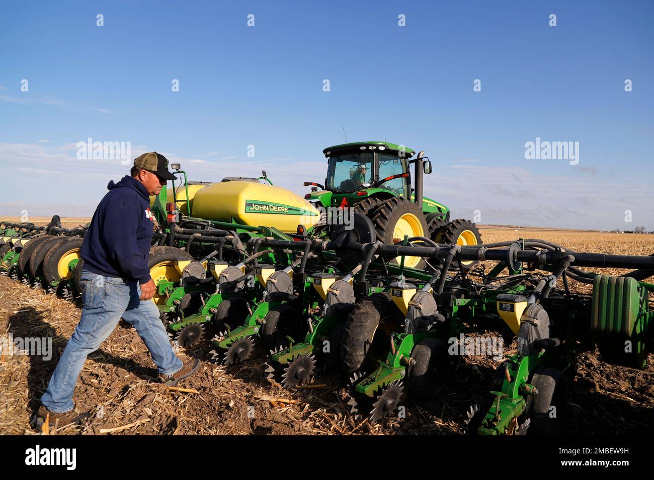 Don Schneider monitors as his son Bradon works a corn planter Friday ...