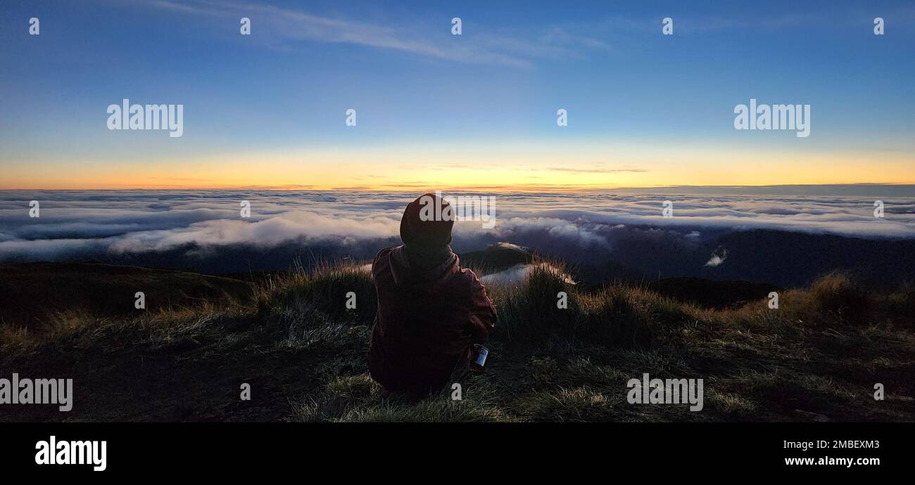 A panorama shot of a person on mount Pulag, watching the stunning view ...