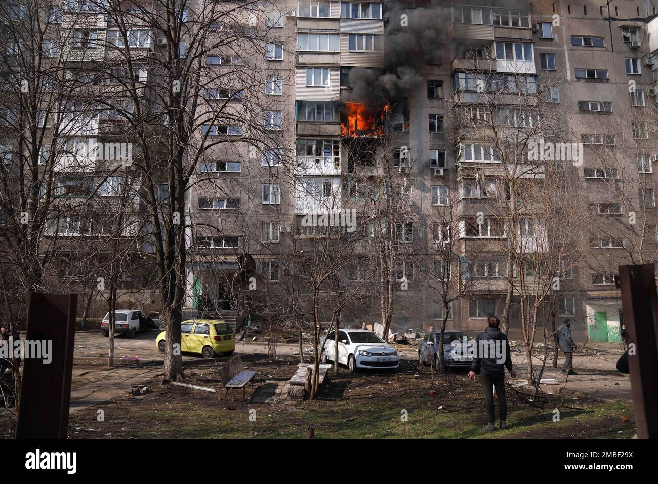 FILE - People look at a burning apartment building after shelling in ...