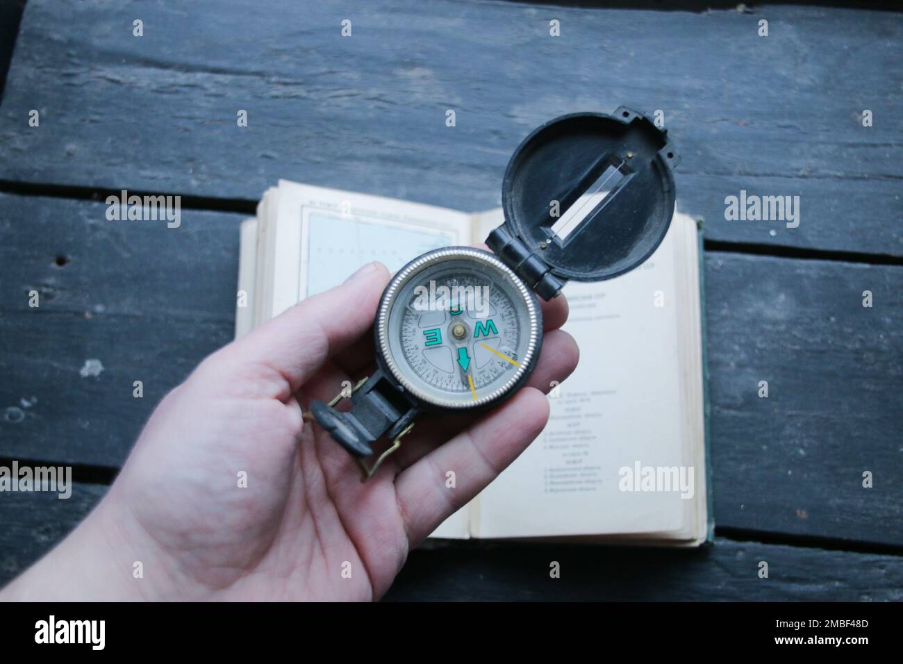 Hand Holding Navigational Compass on retro map background Stock Photo ...