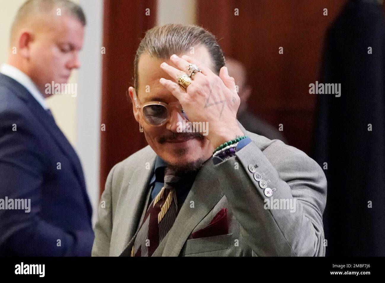 Actor Johnny Depp waves to the courtroom gallery at the Fairfax County ...