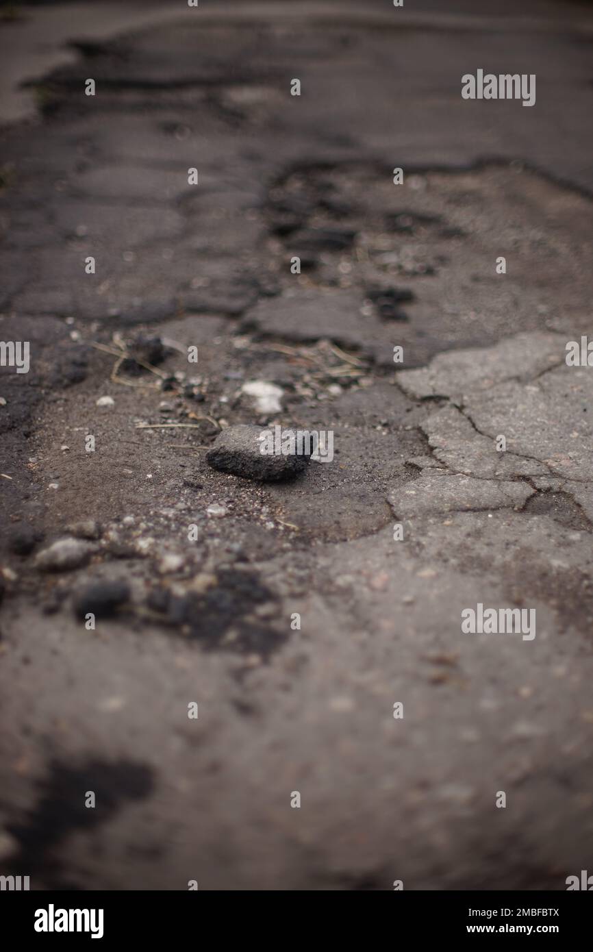 Closeup view of an old broken asphalt road Stock Photo - Alamy
