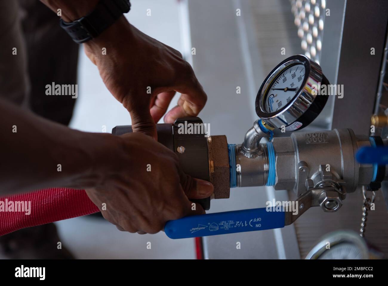 An Airman from the 49th Civil Engineer Squadron hooks up a discharge ...