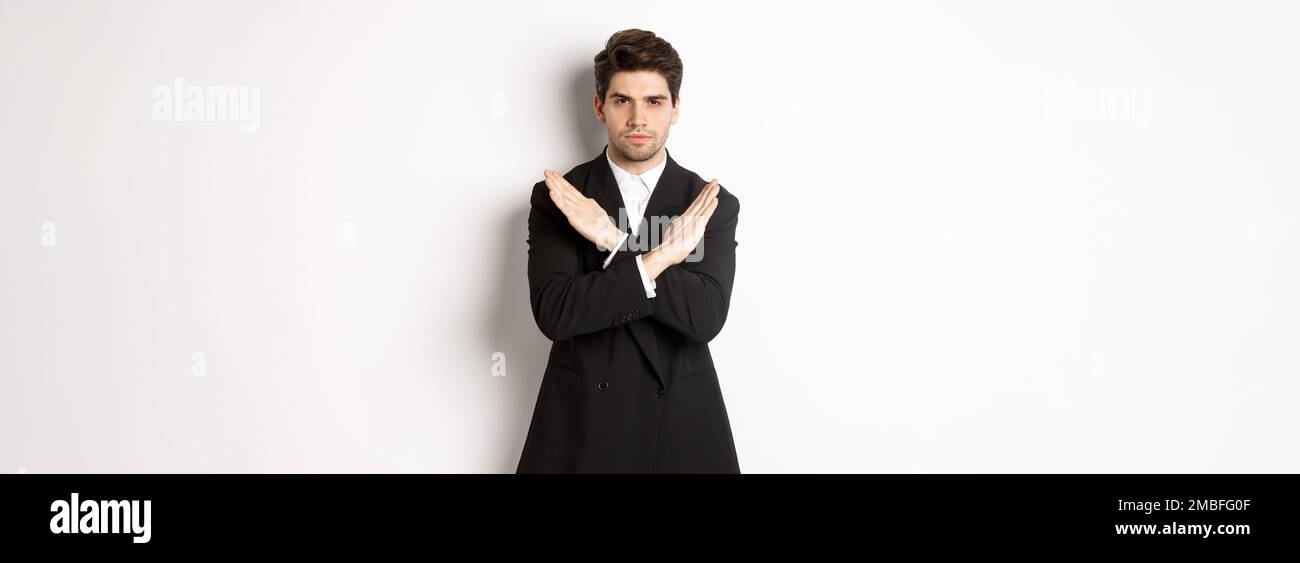 Portrait of serious and concerned man in black suit, showing stop ...
