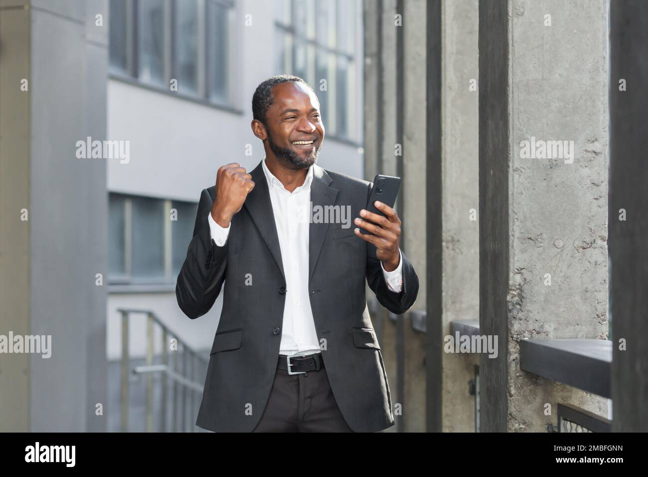 Successful african american boss outside office building using phone ...