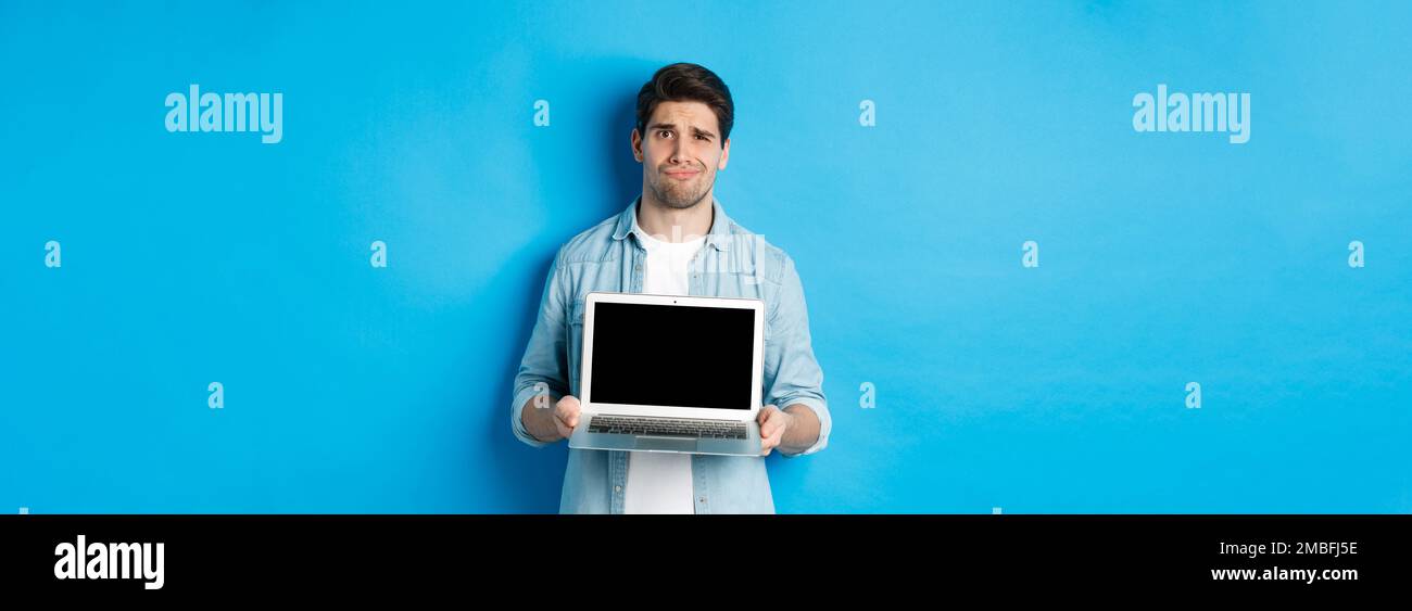 Skeptical and displeased bearded guy showing laptop screen and ...