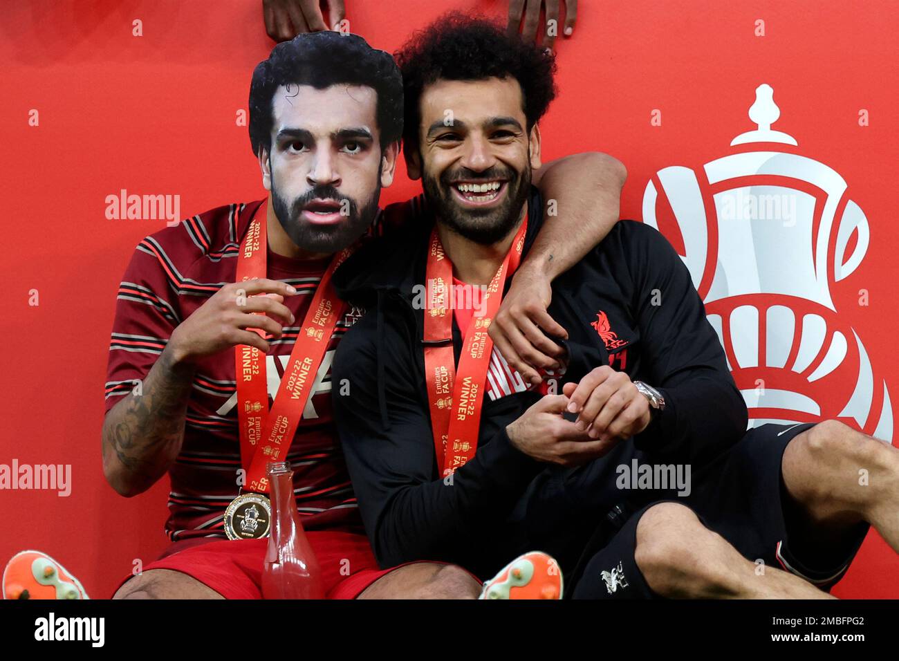 Liverpool's Thiago, wearing a mask of Mohamed Salah, embraces Salah ...
