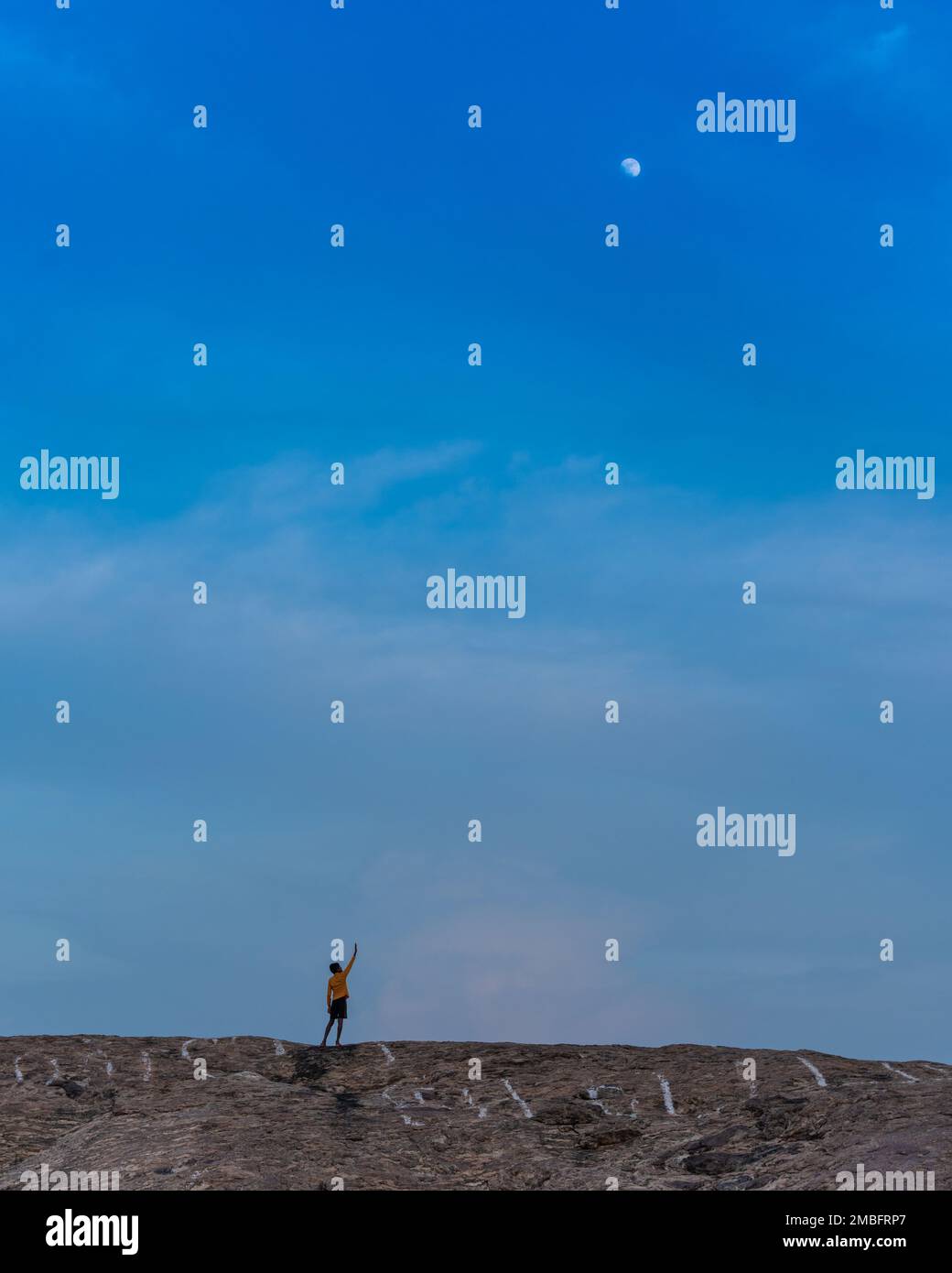 A vertical shot of a kid holding her hand up high trying to reach the ...