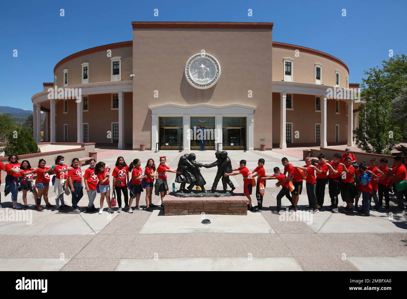 Students from Doña Ana Elementary School pose for a photo with a statue ...