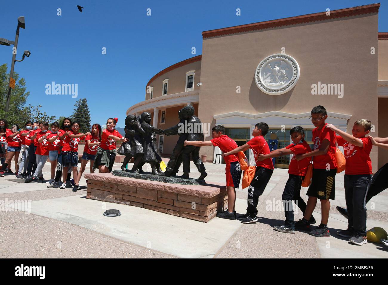Students from Doña Ana Elementary School pose for a photo with a statue ...