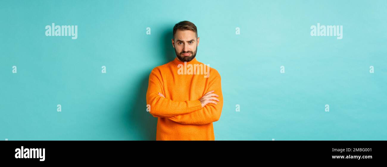 Silly sad guy with beard, sulking and looking offended, cross arms on ...
