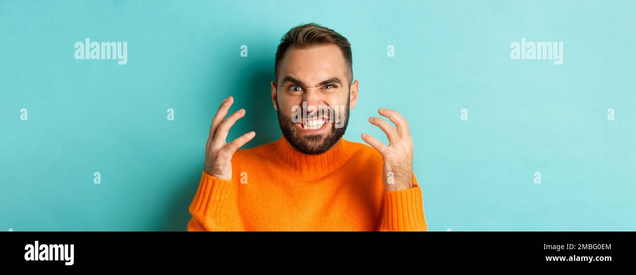 Close-up of angry caucasian man looking mad, grimacing and shaking ...