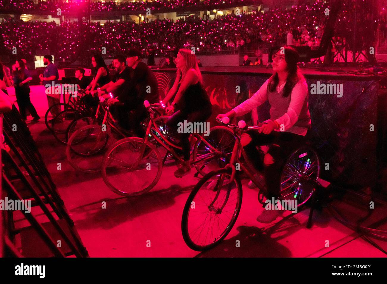 Concertgoers ride stationary bikes during Coldplay's Music of the ...