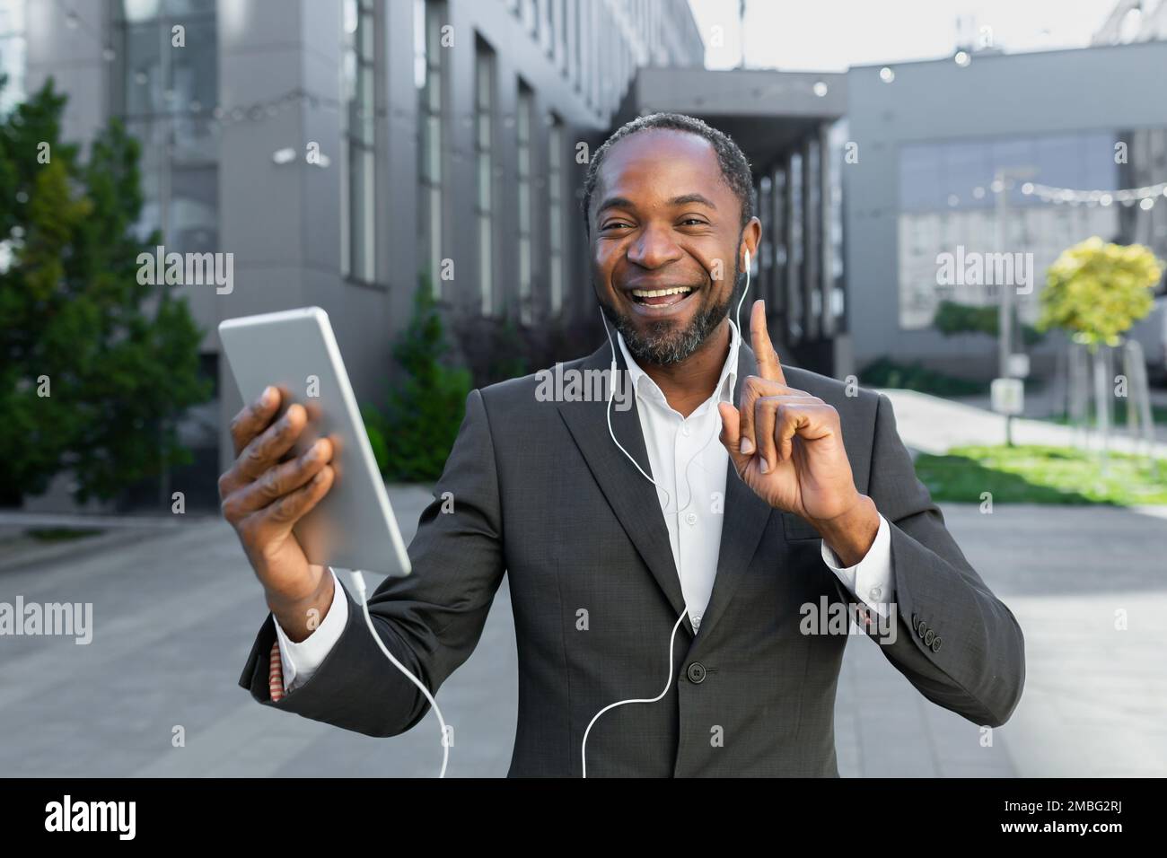Successful african american boss outside office building with tablet ...