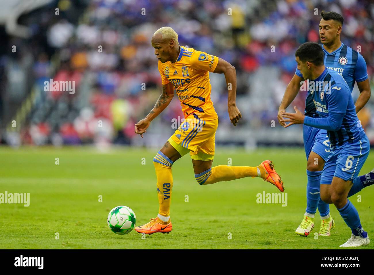 Tigres' Luis Quinonez dribbles the ball chased by Cruz Azul's Erik Lira ...
