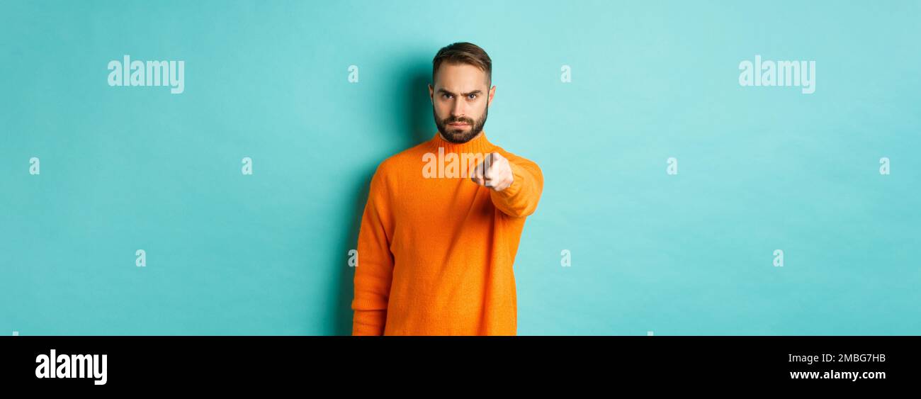 Confident man blame you, frowning and pointing finger at camera, accuse ...